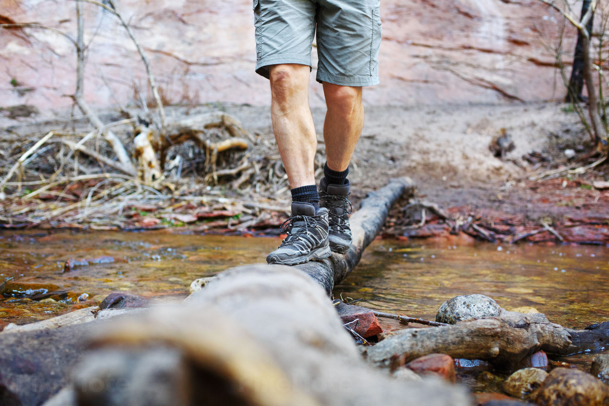 Man Walking on a Log While Crossing Stock Photo - PixelTote