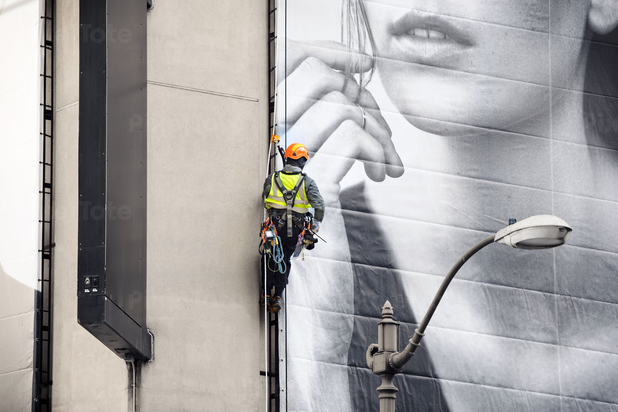Worker Climbing a Rope While Stock Photo - PixelTote
