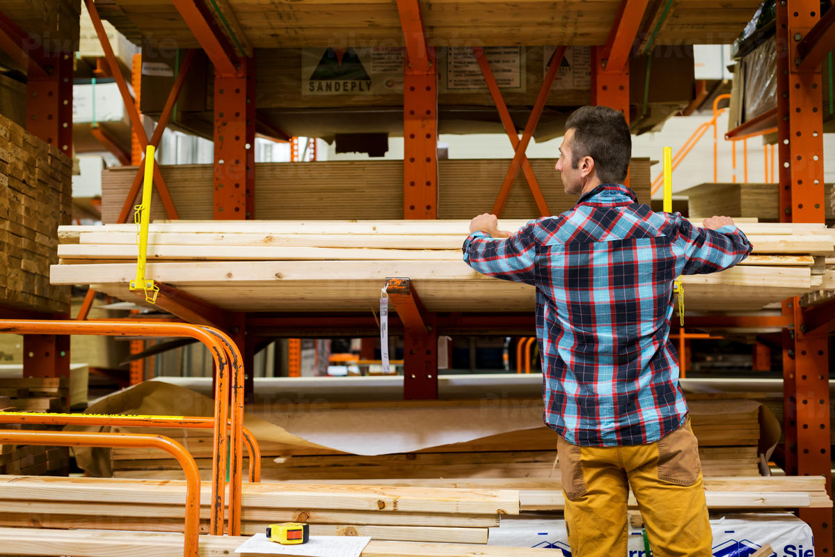 Man Selecting a Wood Board in Stock Photo - PixelTote