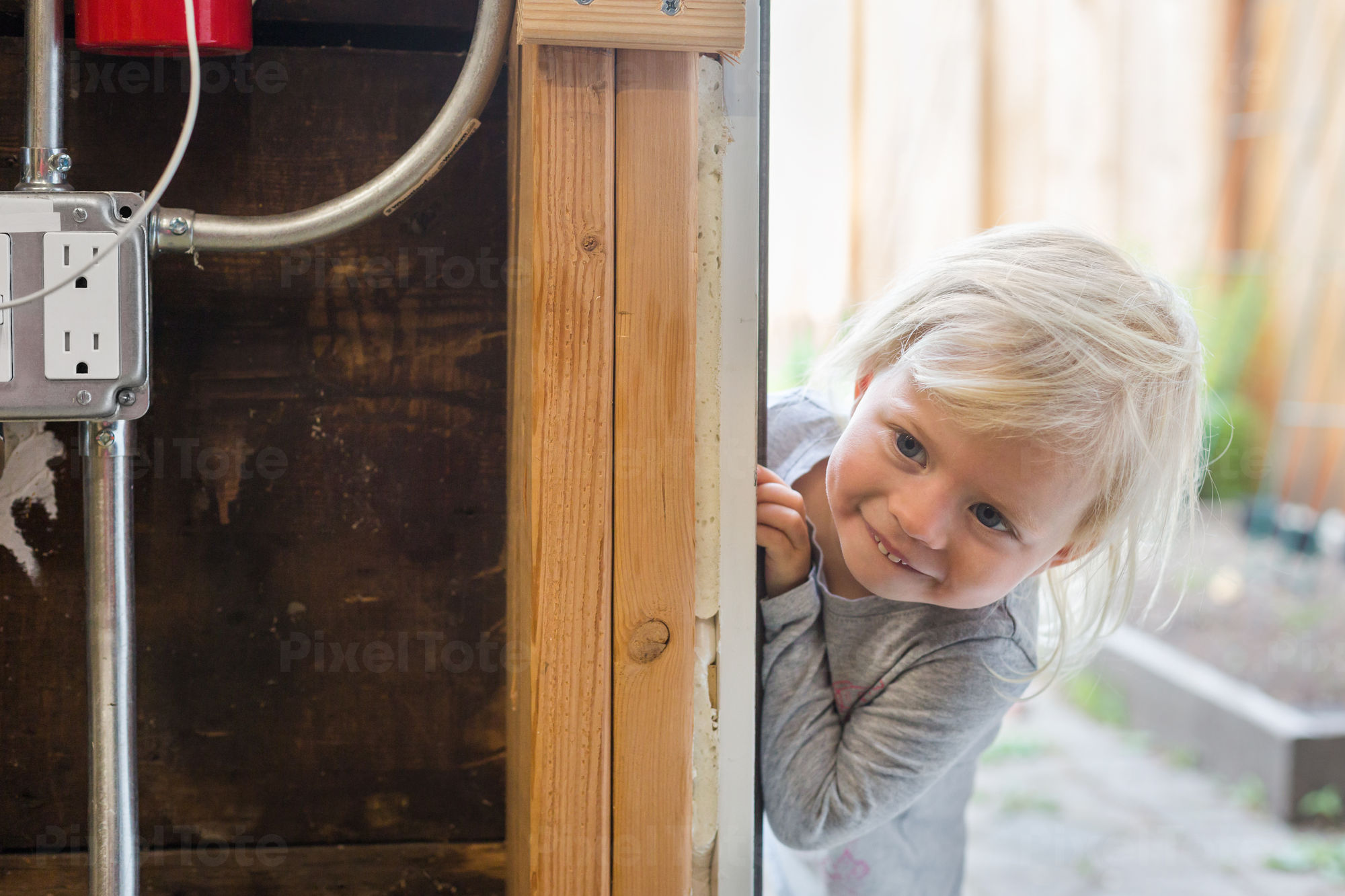 Cute Toddler Girl Peeking from Stock Photo - PixelTote