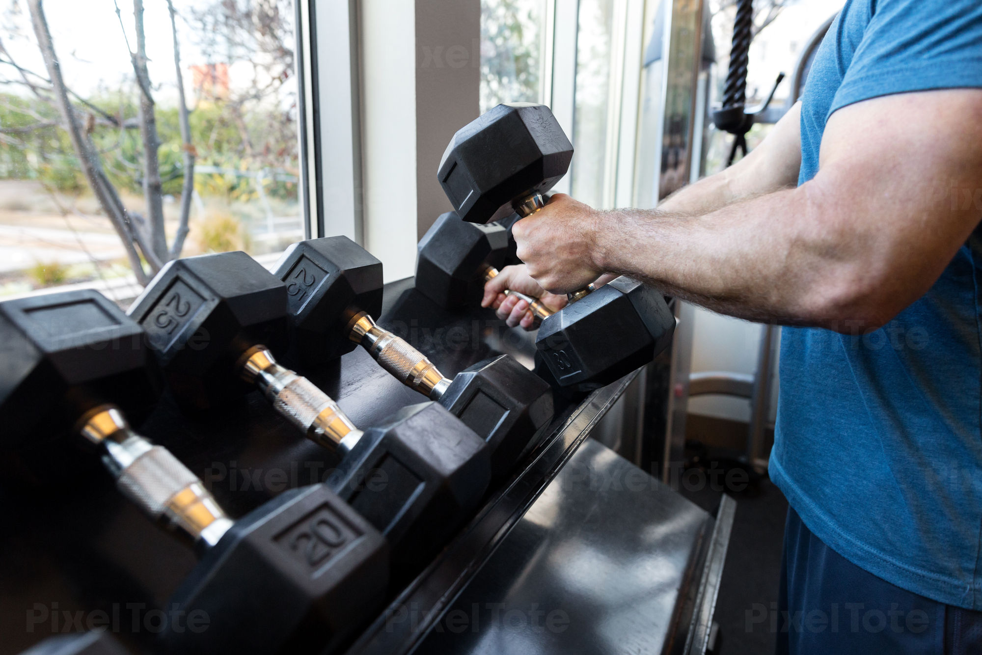 Muscular Man Taking Dumbbells Stock Photo - PixelTote