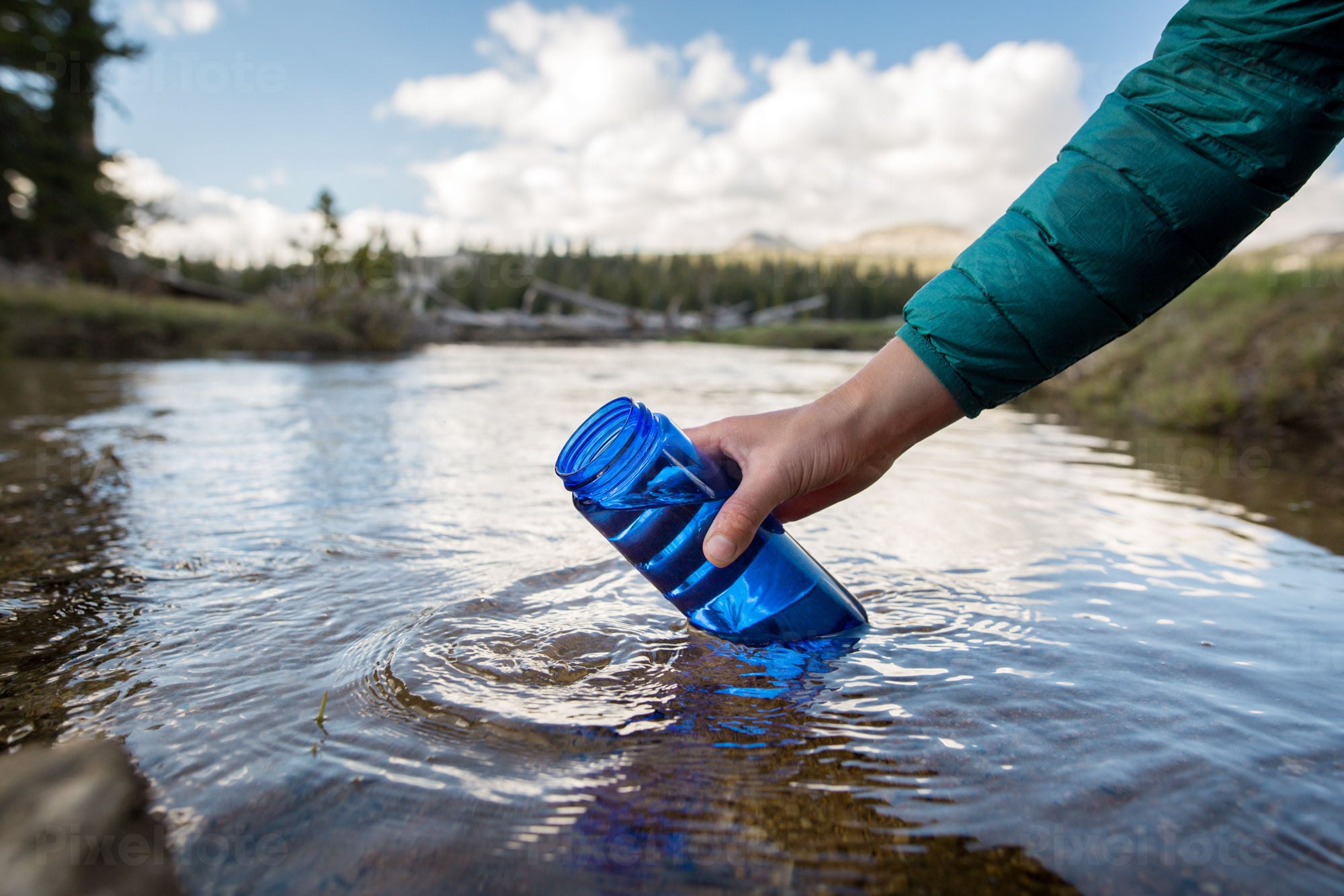 Woman Filling a Bottle with Pure Stock Photo - PixelTote
