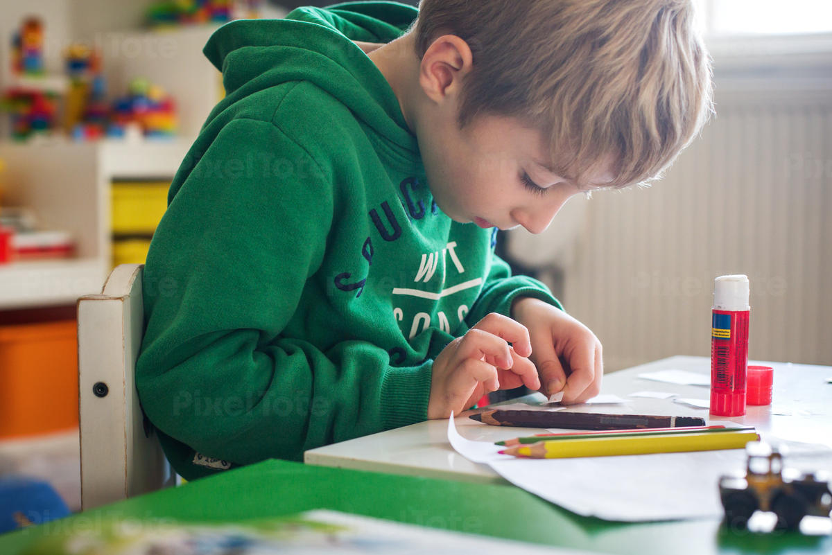Young Boy Glueing a Piece of Stock Photo - PixelTote