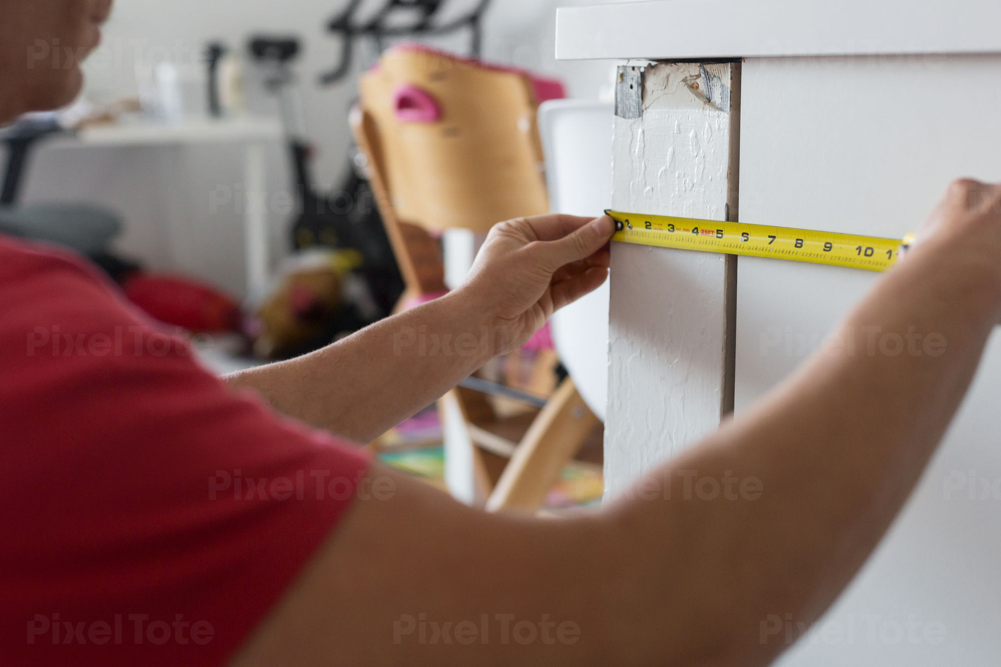 Man Measuring Kitchen Cabinet Stock Photo - PixelTote