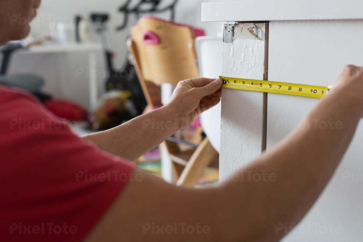 Man Measuring Kitchen Cabinet Stock Photo - PixelTote