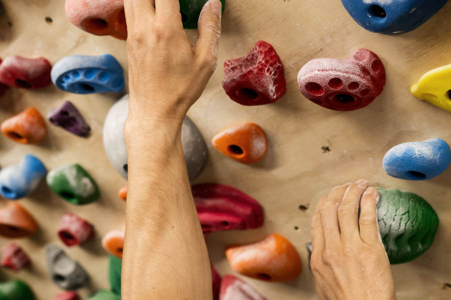 Close-Up of a Climber's Hand Crimping a Narrow Granite Hold Stock Photo