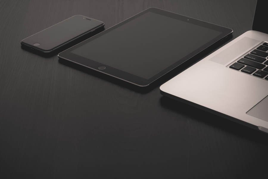 View of a Tablet, Cell Phone and a Laptop on a Black Table Stock Photo ...