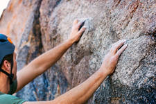 Close-Up of a Climber's Hand Crimping a Narrow Granite Hold Stock Photo