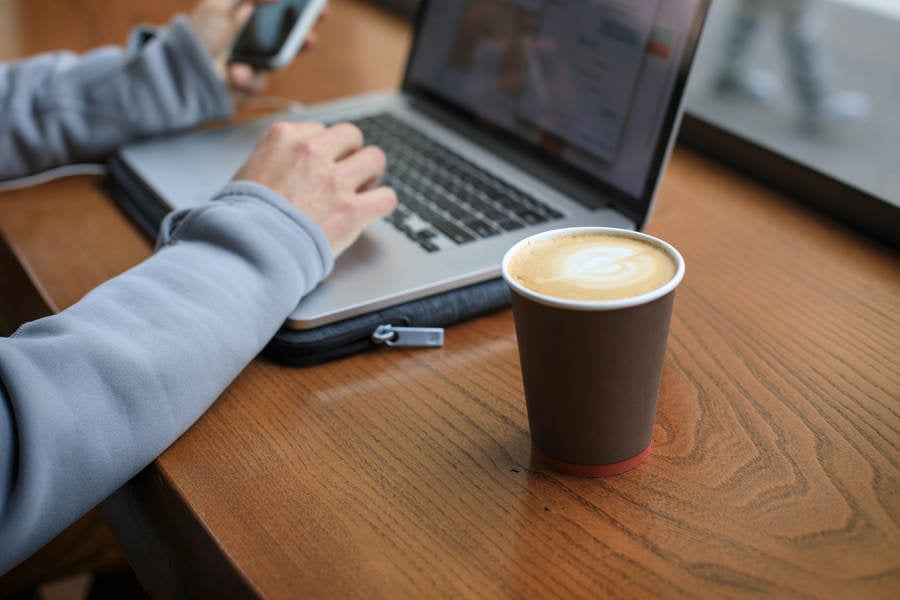 Man Working on a Laptop in Cafe Stock Photo - PixelTote
