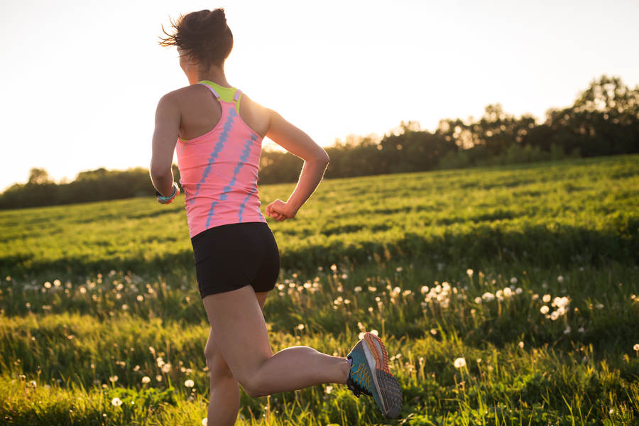 Low-Angle View of an Athletic Woman Running During Sunset Stock Photo